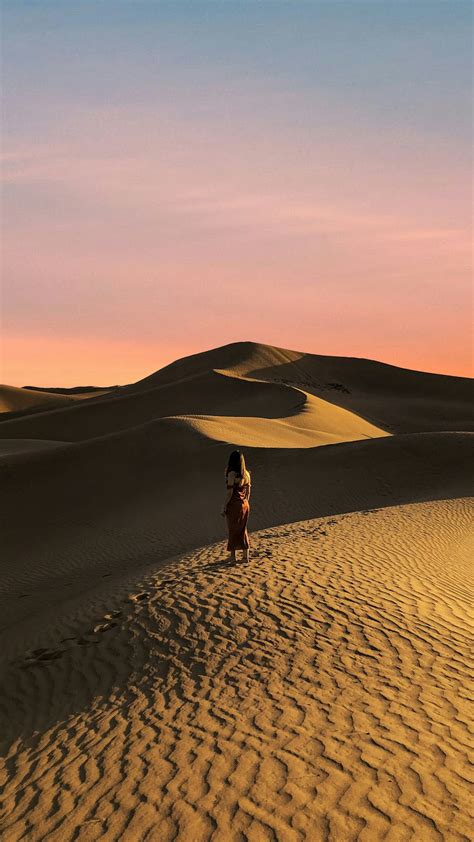 Foto Mujer En Vestido Negro Caminando En El Desierto Durante El Día