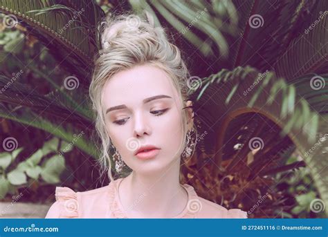 Sensual Young Blonde Beautiful Cute And Elegant Woman Wearing Pink Sitting On The Rock And