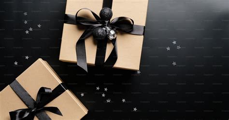 골판지 선물 상자는 검은 바탕에 검은 리본 활과 색종이를 장식했습니다 크리스마스 선물 새해 선물 상자 개념 사진 Unsplash의 묶인 활 이미지
