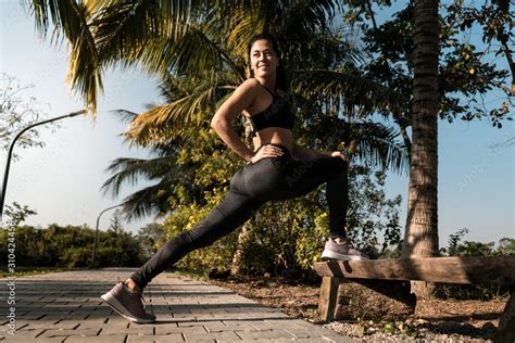 Fit Girl Doing Standing Hamstring Stretch After A Run In Nature Stock