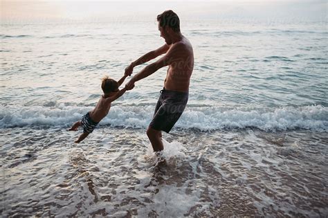 Young Dad And Son Enjoying Tropical Bali Beach Together At Sunse By