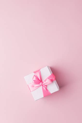 분홍색 종이 배경에 분홍색 사틴 활이있는 선물 또는 선물 상자 상단보기 발렌타인 데이 인사말 카드 블랙 프라이데이 세일 축 하 컨셉 플랫 레이 스타일 2월에 대한 스톡 사진