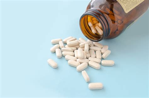 丸薬の写真がアンバーガラス瓶からこぼれ落ちた薬薬の錠剤青い背景に丸薬 カットアウトのストックフォトや画像を多数ご用意 カットアウト