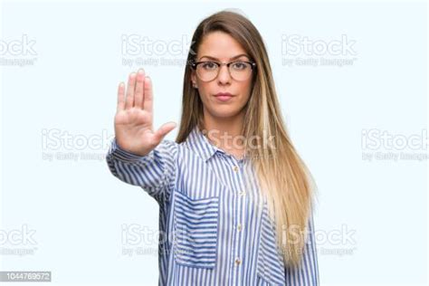 아름 다운 젊은 여 자가 입고 우아한 셔츠와 안경 중지 하 고 손의 종 려를 가진 노래 얼굴에 부정적이 고 심각한 제스처와 경고
