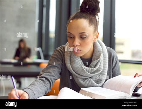 Close Up Image Of A Young Female Student Doing Assignments In Library Close Up Image Of A Young Female Student Doing Assignments In Library