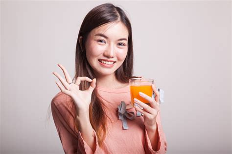 젊은 아시아 여자 음료 오렌지 주스 확인 표시를 표시 합니다 20 29세에 대한 스톡 사진 및 기타 이미지 20 29세
