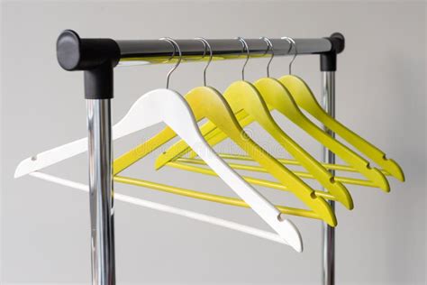 Empty Clothes Hangers On Metal Rail Against Grey Background
