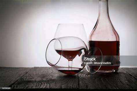 레드 드라이 와인 안경 그 중 하나는 와인의 유적과 함께 측면에 놓여있다 와인 한 병 근처 나무 판자 위에 서 있습니다 백라이트에서 촬영 건조한에 대한 스톡 사진 및 기타