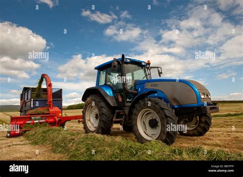 Valtra Tractor Pulling A Kverneland Forage Harvester And Trailer Making