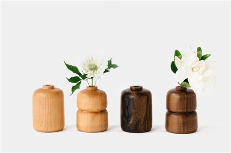 Three Wooden Vases With Flowers In Them On A White Background One Is