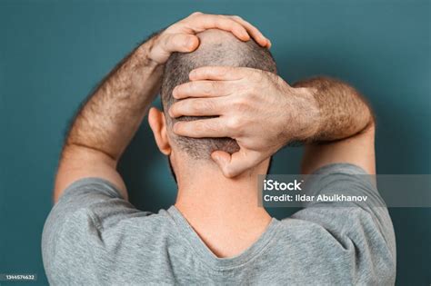 자기 의심과 열등복잡한 대머리 갈색 머리 남자는 그의 손으로 그의 머리를 잡아 후면 보기 청록색 배경 탈모증과 대머리의 개념 머리가 빠지다에 대한 스톡 사진 및 기타 이미지