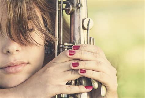 De Zomerportret Van Half Gezicht Van Een Jonge Vrouw Met Saxofoon In Hand Op Een Achtergrond Van