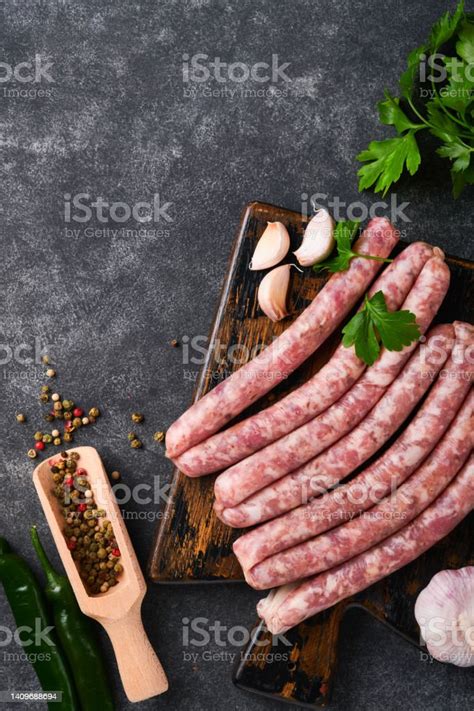 생 소시지 Bratwurst 또는 복사 공간이있는 돌 배경에 향신료가있는 커팅 보드에 재료가있는 소시지 음식 요리 배경 상단