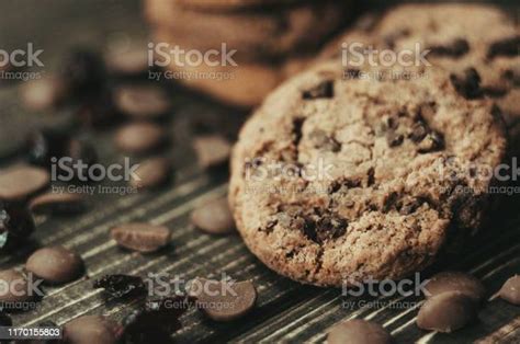 초콜릿 조각과 설탕에 절인 과일을 곁들인 오트밀 쿠키가 나무 테이블에 놓여 있습니다 소박한 테이블입니다 빈티지 토닝 글루텐이없는 식이 유용한 쿠키 공간을 복사합니다 갈색에