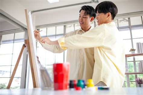 아사인 게이 커플은 집의 거실 Lgbtq 컨셉에서 함께 그림을 그리고 페인트합니다 20 29세에 대한 스톡 사진 및 기타 이미지