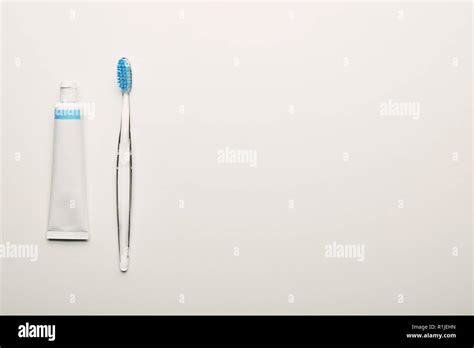 Top View Of Toothbrush And Toothpaste Arranged On White Backdrop
