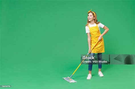 녹색 색 배경 어린이 스튜디오 초상화에 고립 된 집안일을하는 동안 노란색 앞치마 세탁 바닥에 미소 어린 소녀 주부 1213의