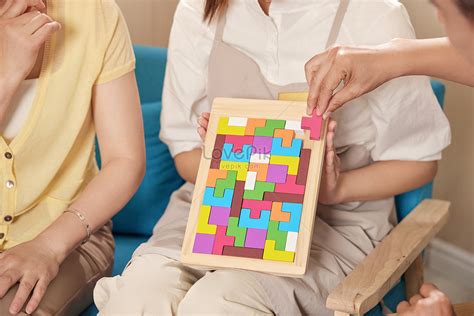 퍼즐 조각을 들고 있는 간병인과 노인의 클로즈업 사진 무료 다운로드 Lovepik