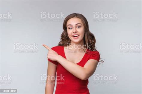 쾌활한 젊은 갈색 머리 여자의 초상화 왼쪽을 가리키고 미소 사람들을 초대 하는 프로모션 20 24세에 대한 스톡 사진 및 기타