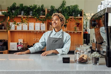 Smiling Female Bartender Looking Away While Standing At The Counter