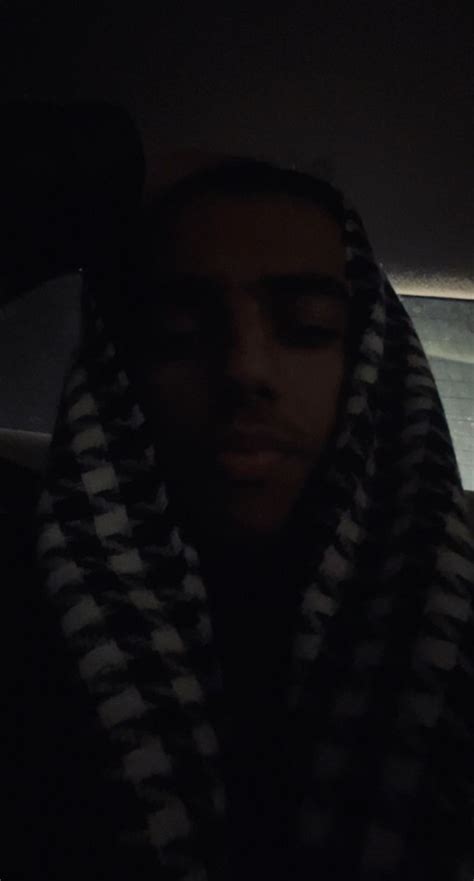 A Man Wearing A Hooded Towel In The Dark