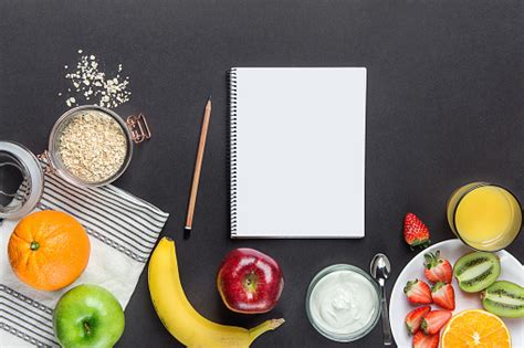 건강 한 아침 식사 재료 오트밀 사과 바나나 딸기 키 위 오렌지 요구르트 주스 숟가락 블랙 테이블 위에 텍스트에 대 한 빈 이랑
