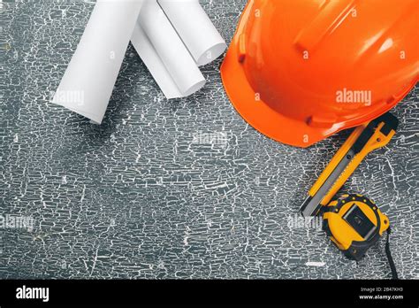 Engineer Workplace With Blueprints Compass Pencil And Safety Helmet