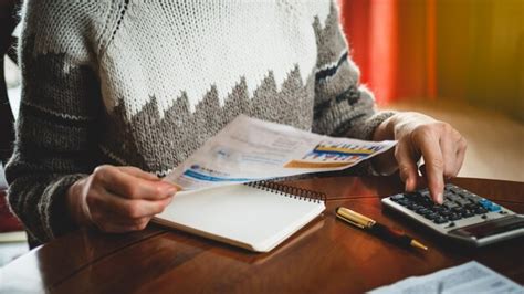 Premium Photo Closeup Of A Woman Examining Her Utility Bills And Ready To Make Calculations