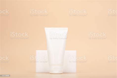 가벼운 베이지 색 배경에 대한 흰색 광택 튜브의 손 또는 얼굴 크림 0명에 대한 스톡 사진 및 기타 이미지 0명 가꿔주기