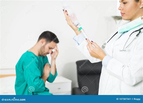 Female Doctor Prepares An Injection While The Patient Is In Bed Stock