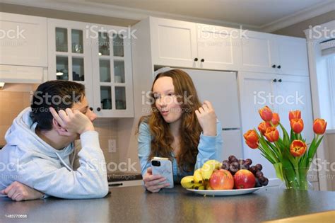 부엌에서의 의사 소통 친구 Odnoklassniki 포도 과일 손에 전화기를 들고 십대 소녀와 소년 캐비닛 꽃 운동복을 입은 튤립 이야기 함께 시간 보내기 건강한 식생활에