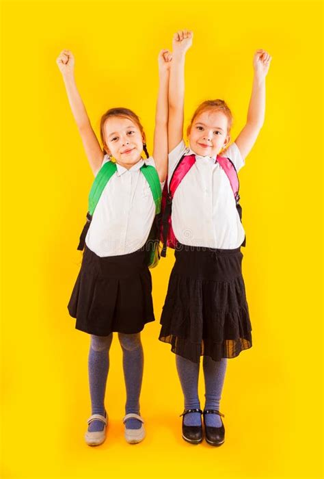 Dos Colegialas Amigables Uniformadas Cogiendo La Mano Imagen De Archivo