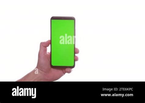 Phone in the hand close up isolated at green background. Phone screen is white screen key ...