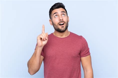 Hombre Guapo Joven Con Barba Sobre Fondo Azul Aislado Pensando En Una
