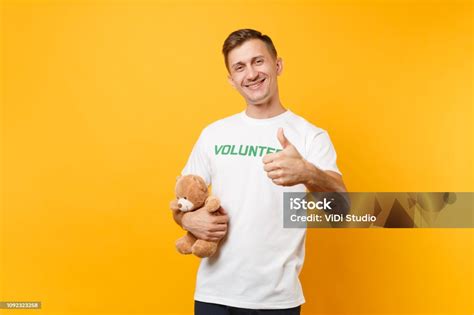 화이트에서 좋은 남자의 서 면된 비문 녹색 제목 자원 봉사 T 셔츠 노란색 배경에 고립 된 테 디 베어 봉 제 장난감 개최 자발적인 무료 지원 도움말 자선 총 작업 개념 T