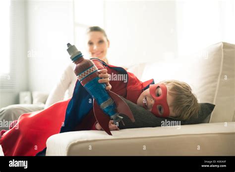 Cute Superhero Boy Paying With Toy Rocket In The Living Room With His