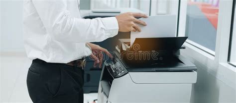 Hand Putting A Document Paper Into Printer Scanner Or Laser Copy Machine In Office Stock Image