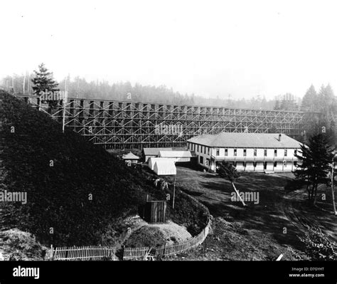 This Image Shows A Spruce Camp Near A Railroad Trestle Located Near