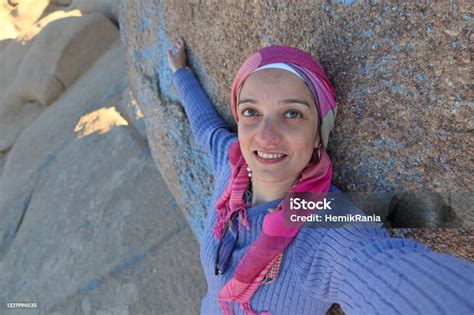 보라색 풀오버와 헤이즐 눈을 가진 머리 덮개를 입은 쾌활한 젊은 여성이 이집트의 푸른 사막 바위 한가운데에서 셀카를 찍고 있습니다 45 49세에 대한 스톡 사진 및 기타