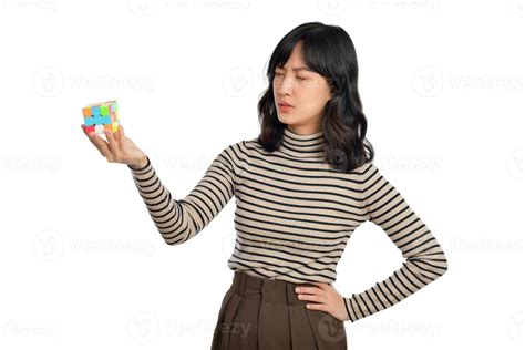 asian woman holding a puzzle cube standing on white background solving