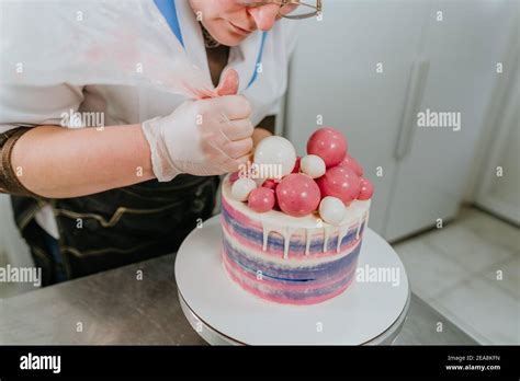Female Confectioner Decorating Birthday Cake In The Confectionery