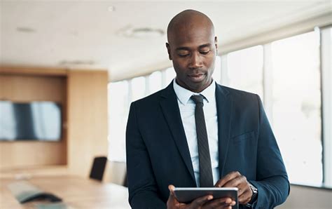 흑인 태블릿 및 기업 전략 계획 연구 또는 회의실에서 온라인 브라우징 프로젝트 계획 또는 일정을 위해 터치스크린 또는 모바일 앱에서 작업하는 아프리카계 미국인 사업가 남자