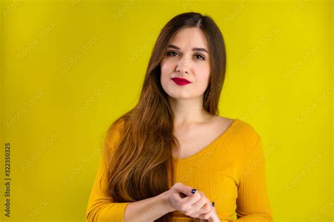 Nice Brunette Girl With Long Hair With A Smile In A Yellow Jacket Rejoices On A Yellow