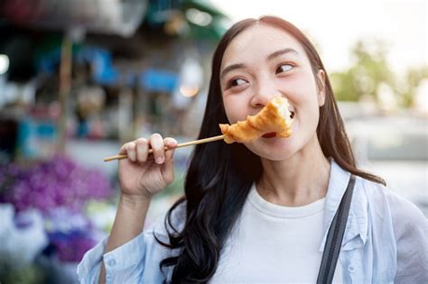 유쾌한 아시아 여성이 여름날 도시를 산책하면서 태국의 길거리 음식을 즐깁니다 25 29세에 대한 스톡 사진 및 기타 이미지 25 29세 거리 걷기 Istock