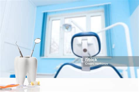 구강 치과 위생 치과의 자 및 램프와 흐리게 치과 사무실 배경에 대 한 칫 솔 근처에 탐색기 프로브 악기와 건강 한 하얀 치아와