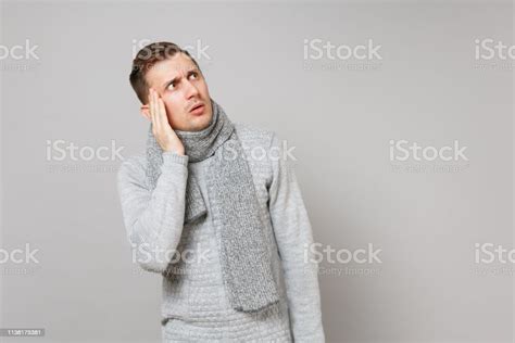 회색 스웨터 얼굴 가까이 손을 잡고 회색 배경에 고립 된 옆에 있는 스카프에 관련 된 젊은 남자 건강 한 패션 라이프 스타일