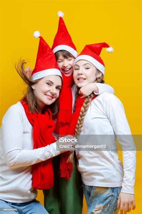 노란 배경을 통해 축하 산타 모자에서 세 백인 윈섬 축제 소녀의 가족 14 15 살에 대한 스톡 사진 및 기타 이미지 14 15 살 35 39세 8 9 살 Istock