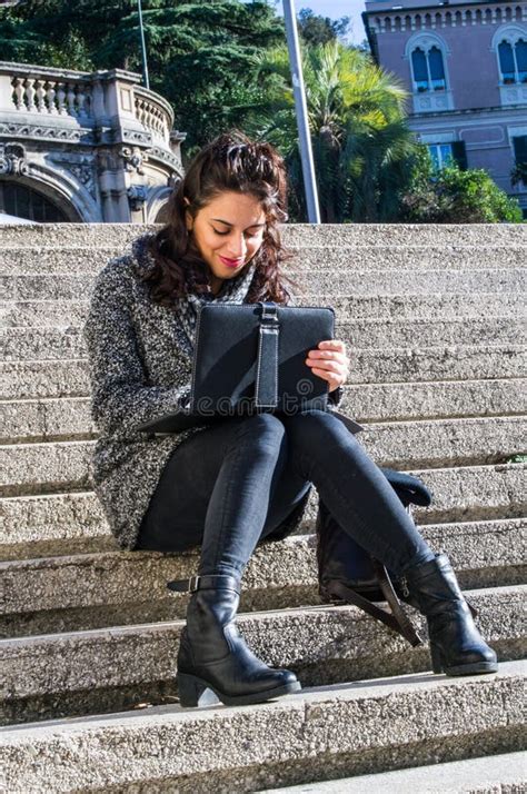 Cute Girl Looking At Her Tablet And Sitting On Stairs Stock Image
