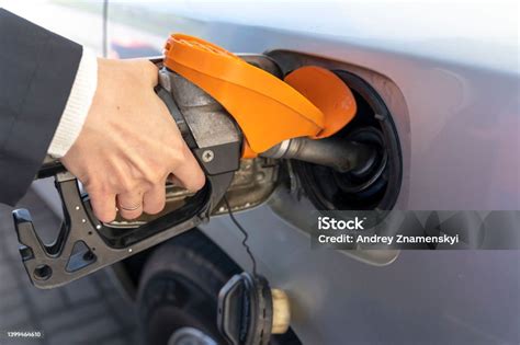 한 여성의 손이 자동차 탱크의 목에 급유 총을 쥐고 있습니다 소녀는 차에 연료를 보급합니다 가솔린에 대한 스톡 사진 및 기타 이미지 Istock