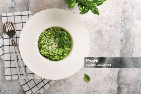 이탈리아 리조또 페스토 소스 또는 야생 마늘 페스토 바질 파르 메산 치즈 및 오래된 밝은 회색 테이블 배경에 화이트 와인 한